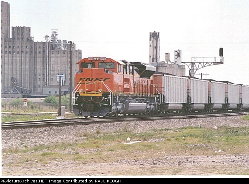 As the rear DPU BNSF 9376 rolls past the grain silos at Saginaw Interlock